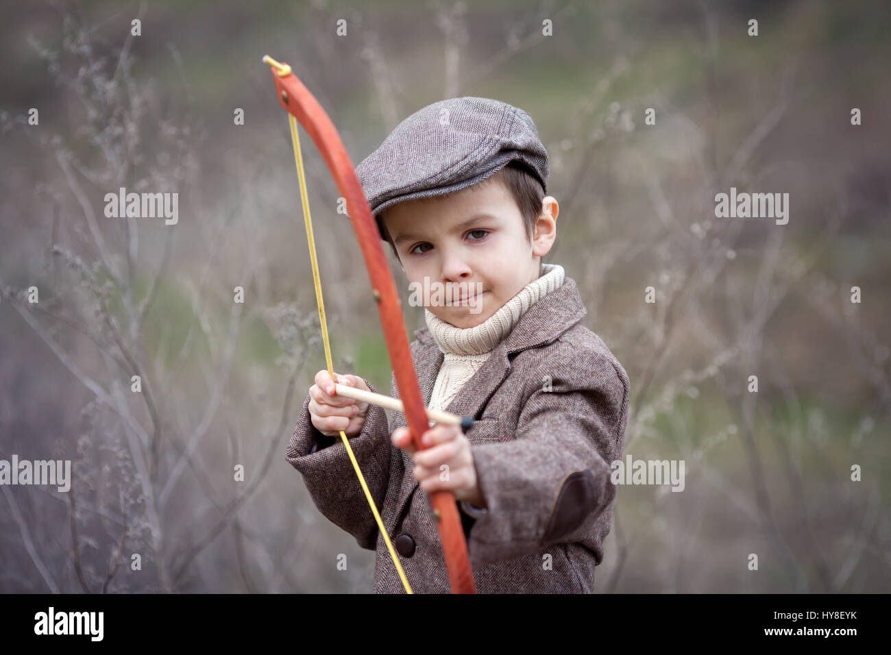 Adorable little preschool boy, shoot with bow and arrow at target in ...