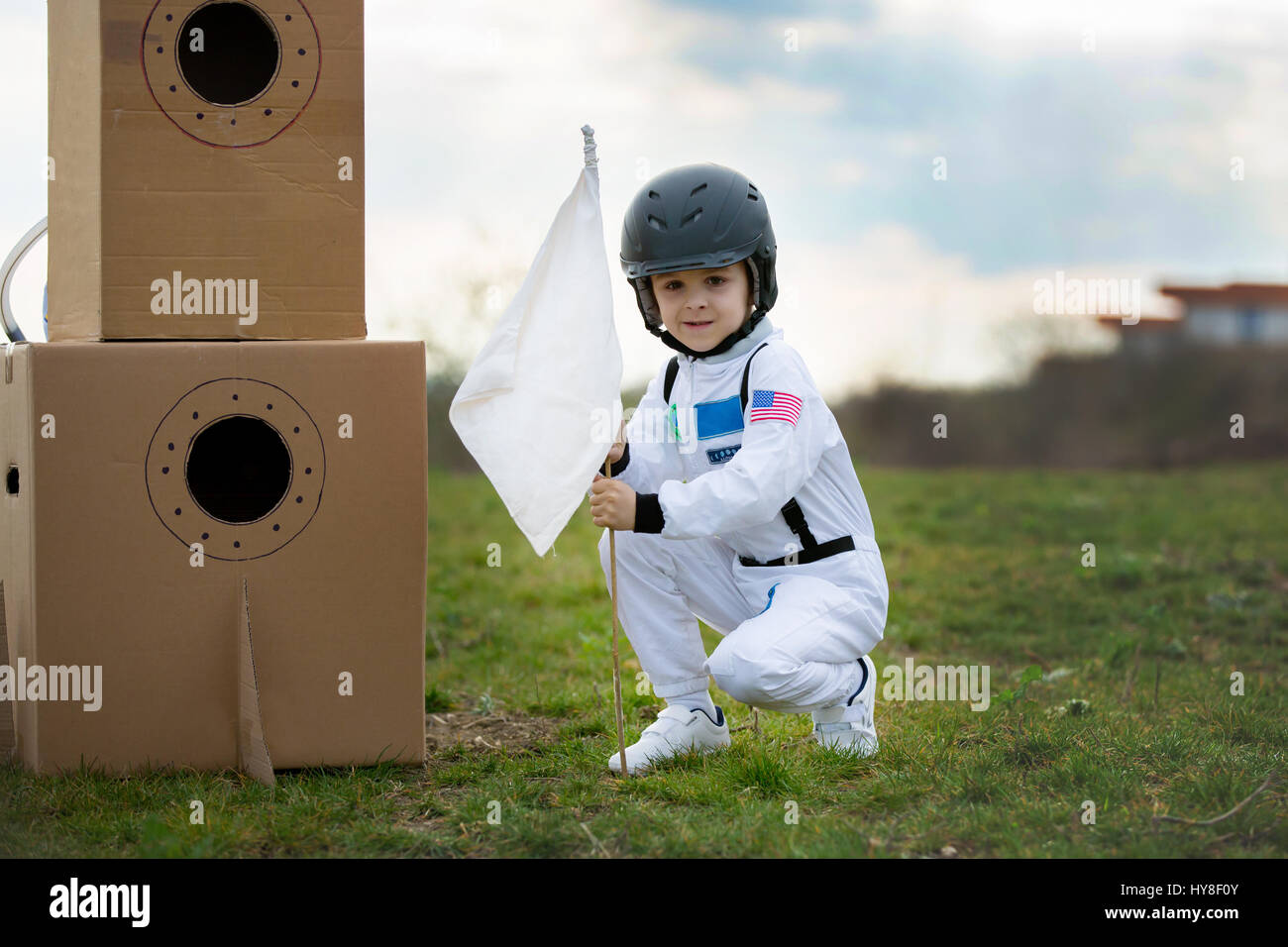Adorable little boy, dressed as astronaut, playing in the park with ...