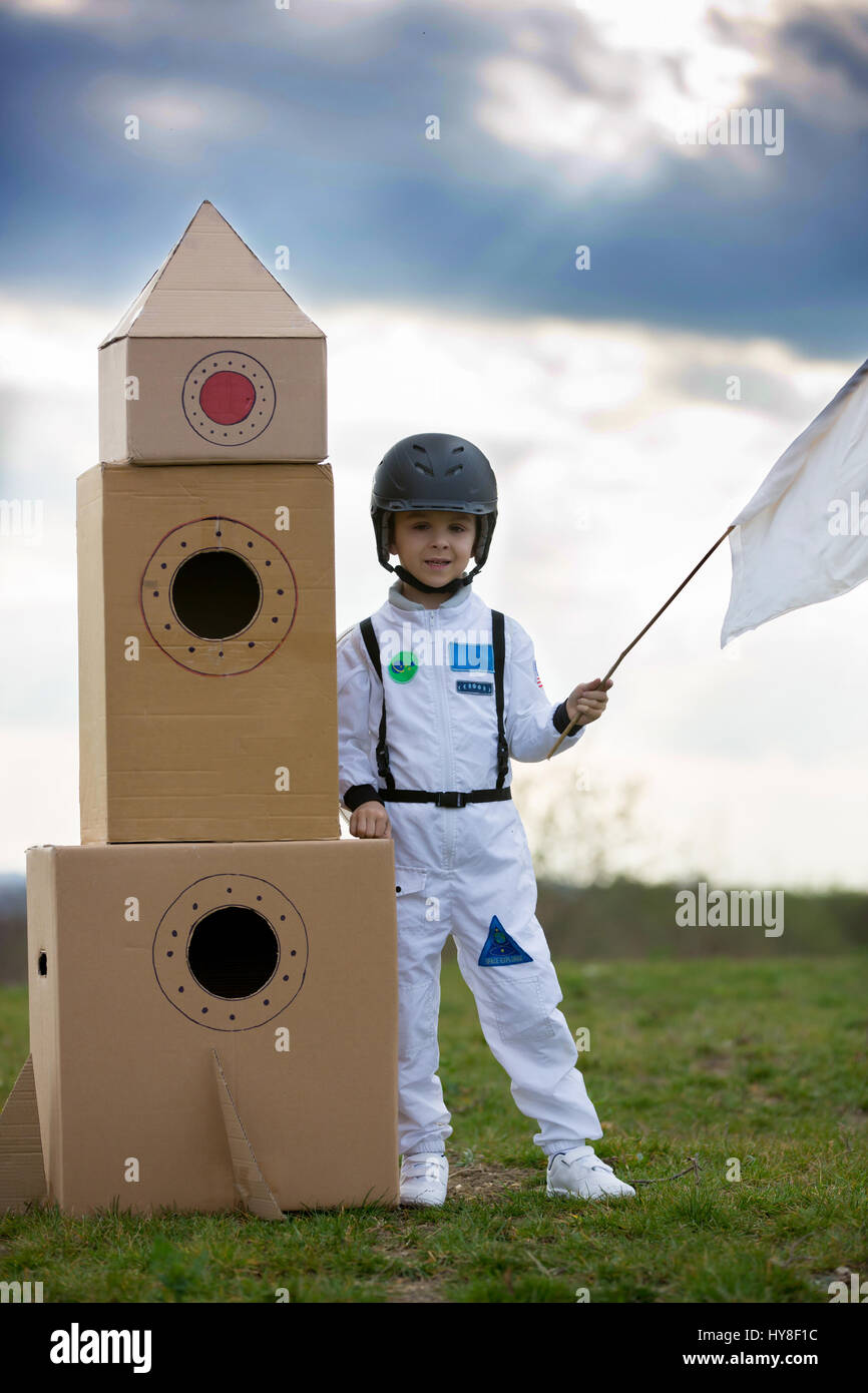Adorable little boy, dressed as astronaut, playing in the park with ...