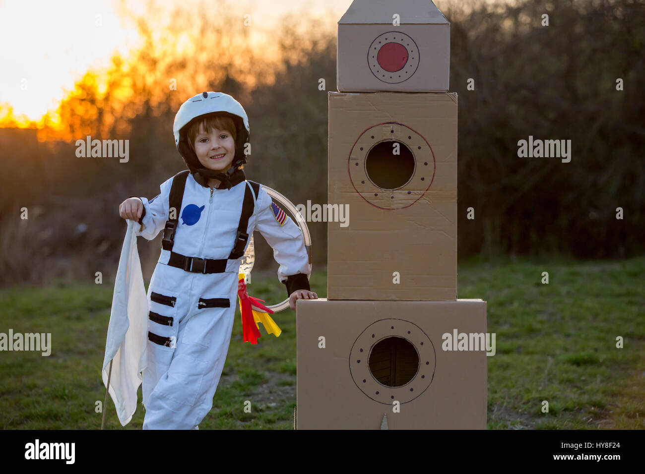 Adorable little boy, dressed as astronaut, playing in the park with ...