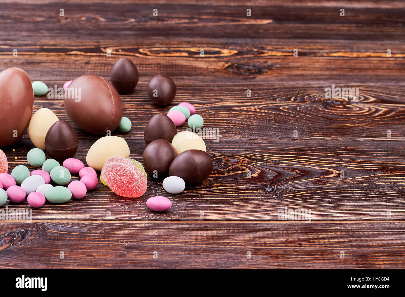 Sweets on brown wood. Candies and chocolate eggs. Confectionery to make ...