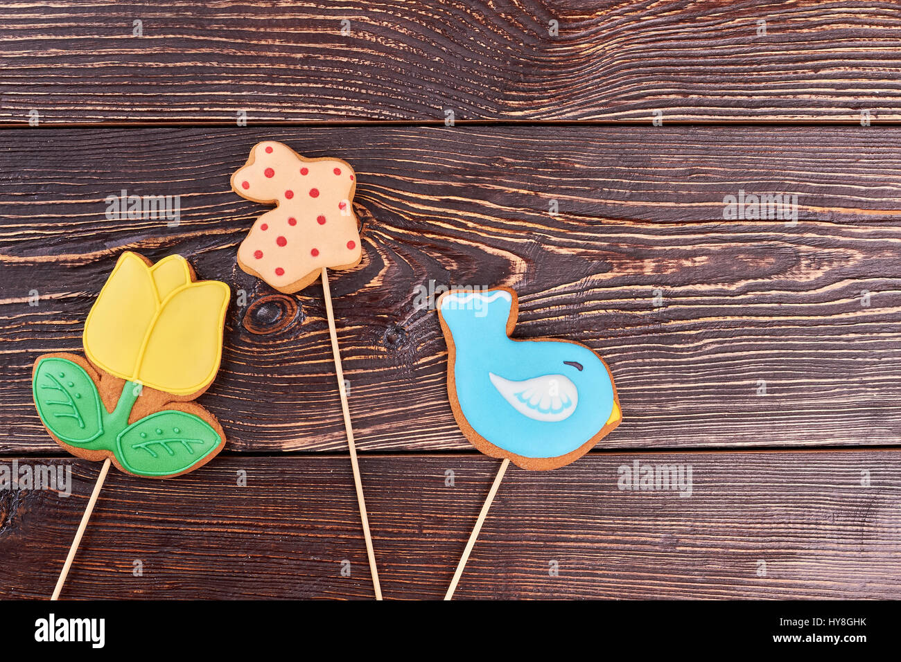 Cookies on sticks, wood background. Top view of glazed biscuits. Easter ...