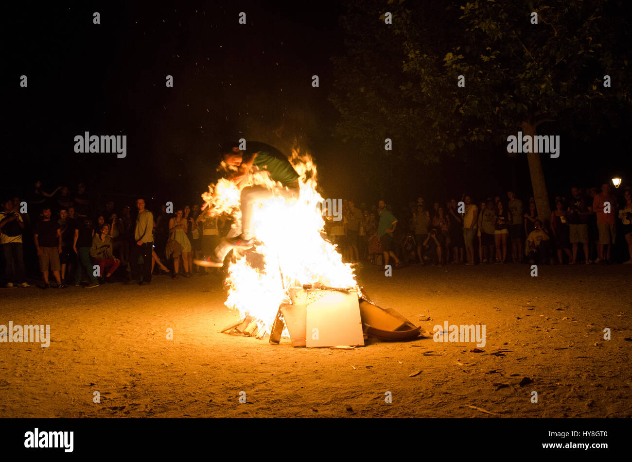 A man jumping through the fire of a bonfire during Saint John's Eve in ...