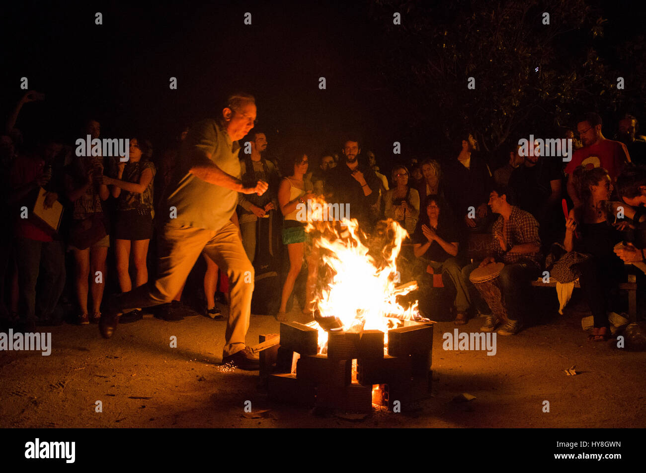 A man running to jump a bonfire during Saint John's Eve in Madrid ...