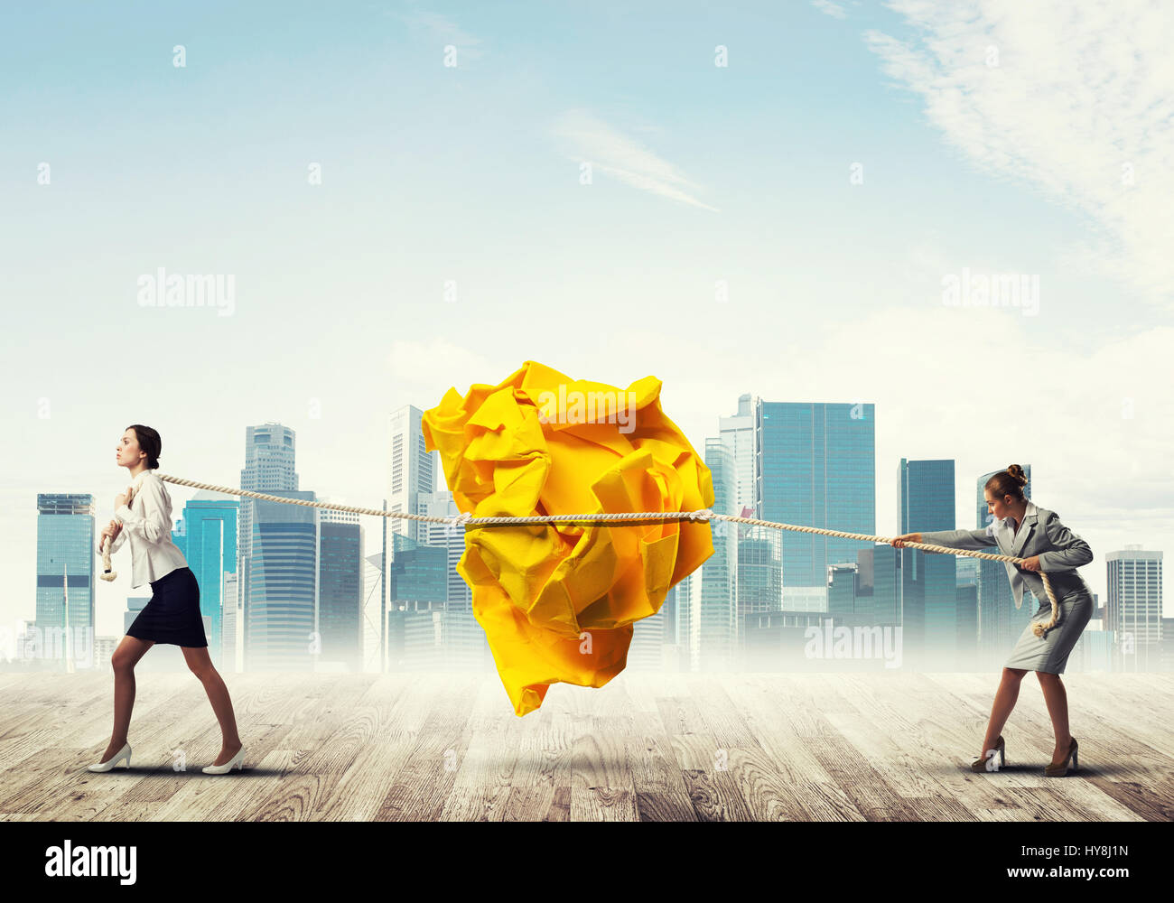 Two women pulling with effort big crumpled ball of paper as creativity ...