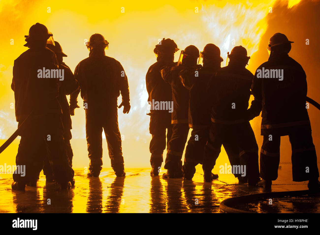 Group of eight firefighters during fire fighting exercise Stock Photo ...