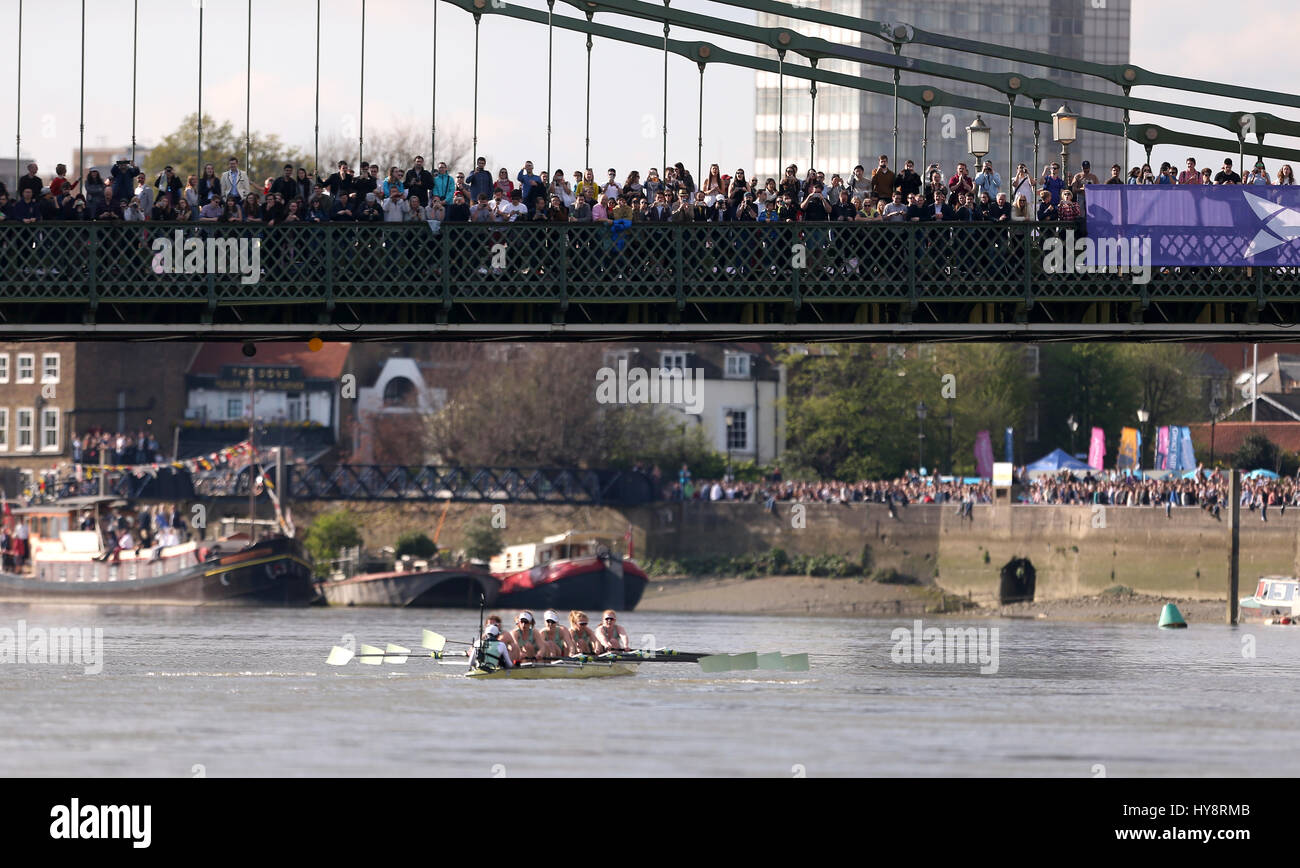 Spectators on a bridge watch the Women's Boat Race on the River Thames ...