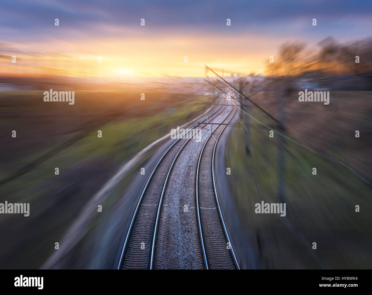 Railroad in motion at sunset. Railway station with motion blur effect ...