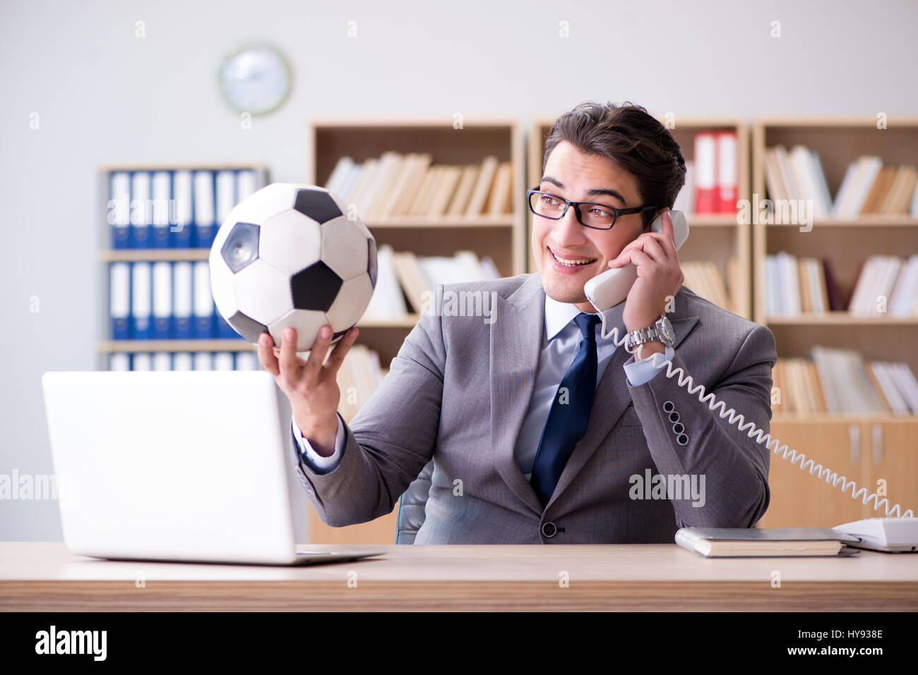 Businessman with football ball in office Stock Photo - Alamy