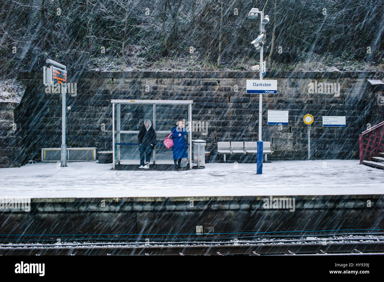 Two people waiting for a train in the snow Stock Photo - Alamy