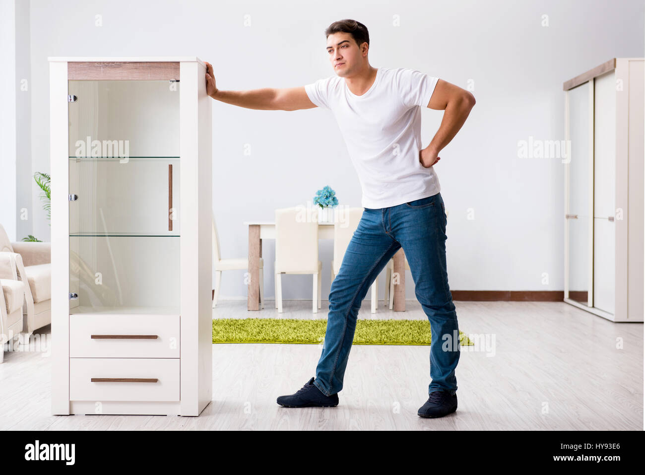 Young man moving furniture at home Stock Photo - Alamy