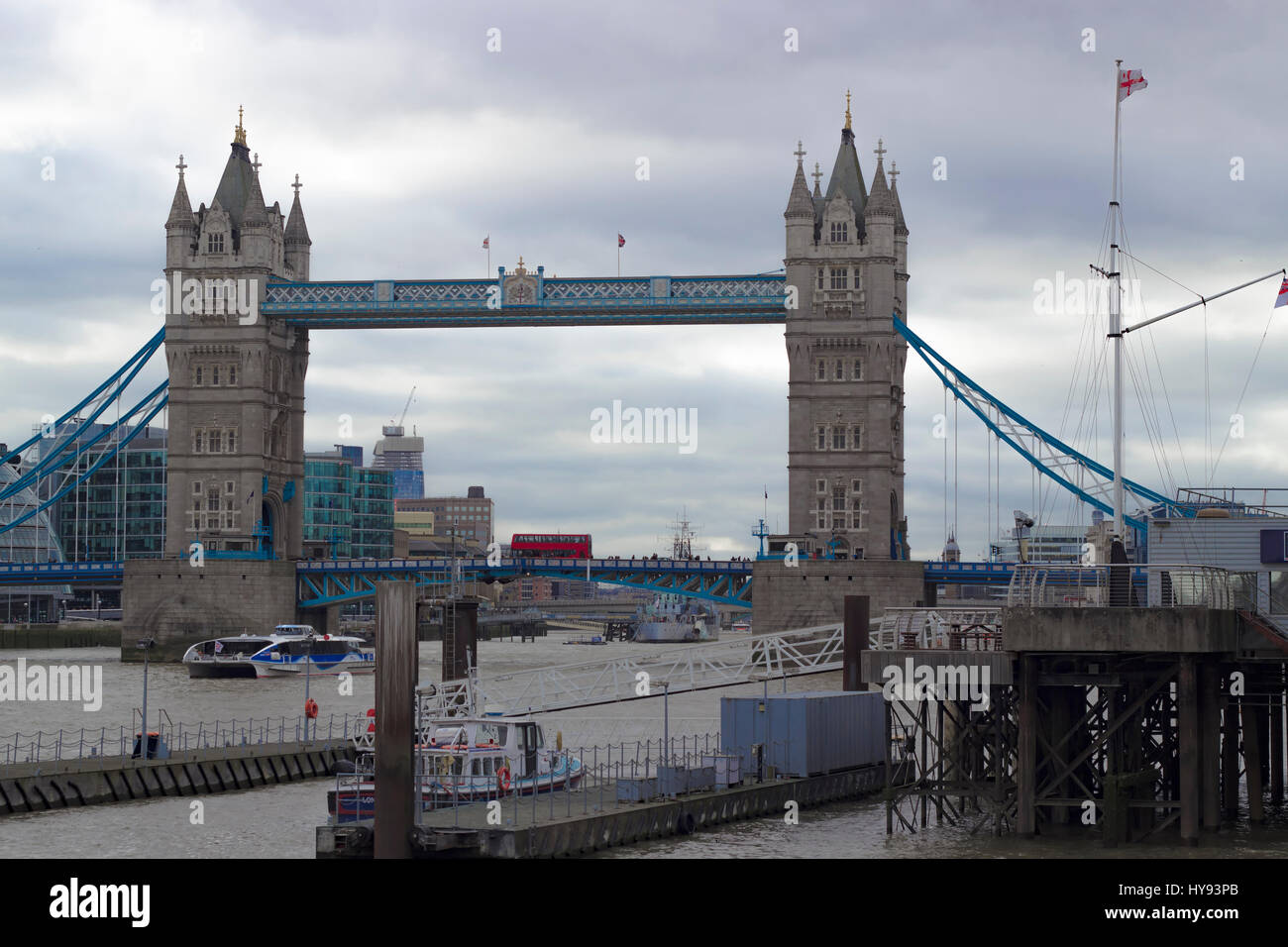 Red British bus driving over the famous and iconic Tower Bridge of ...