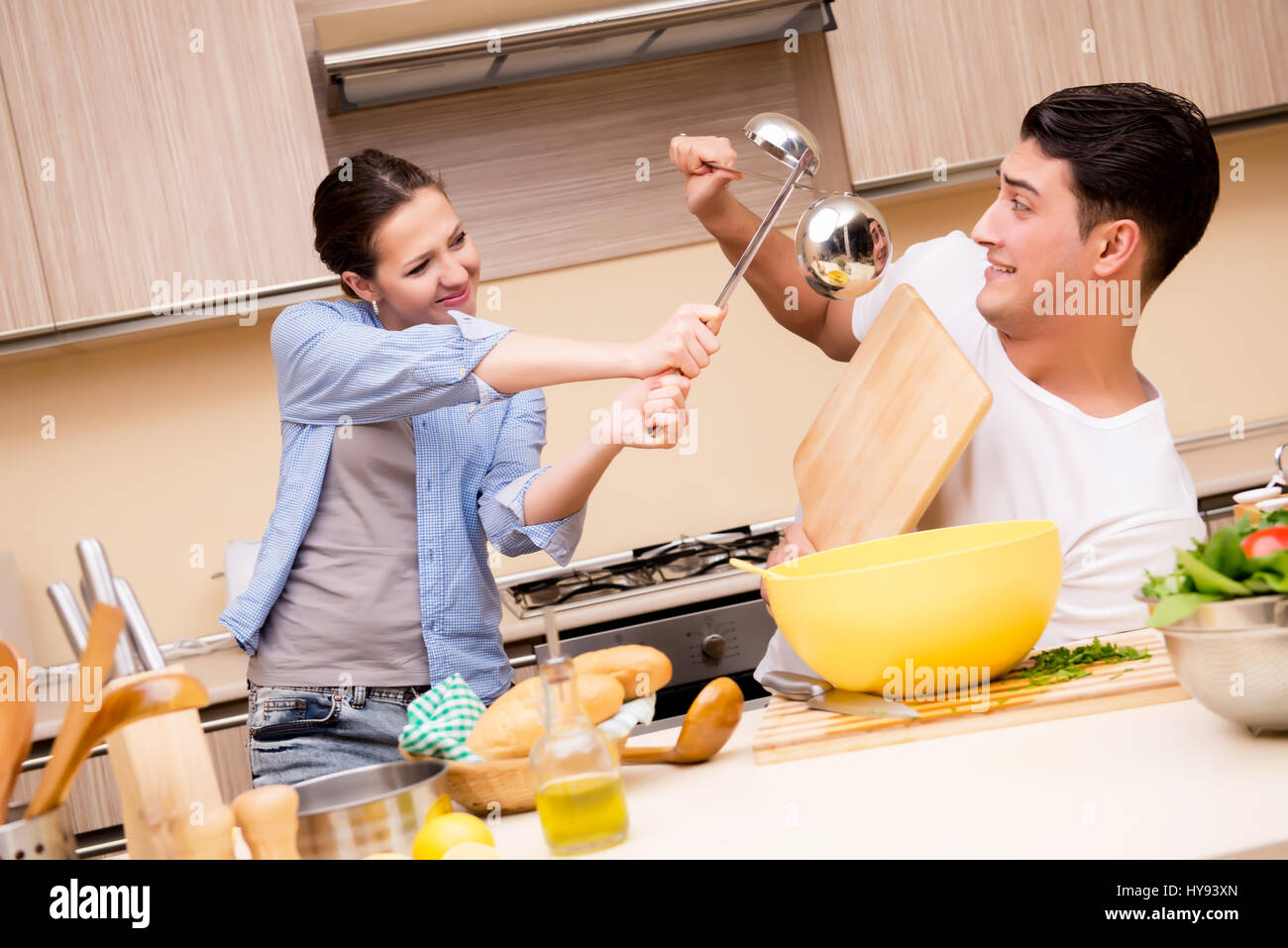 Young family doing funny fight at kitchen Stock Photo - Alamy