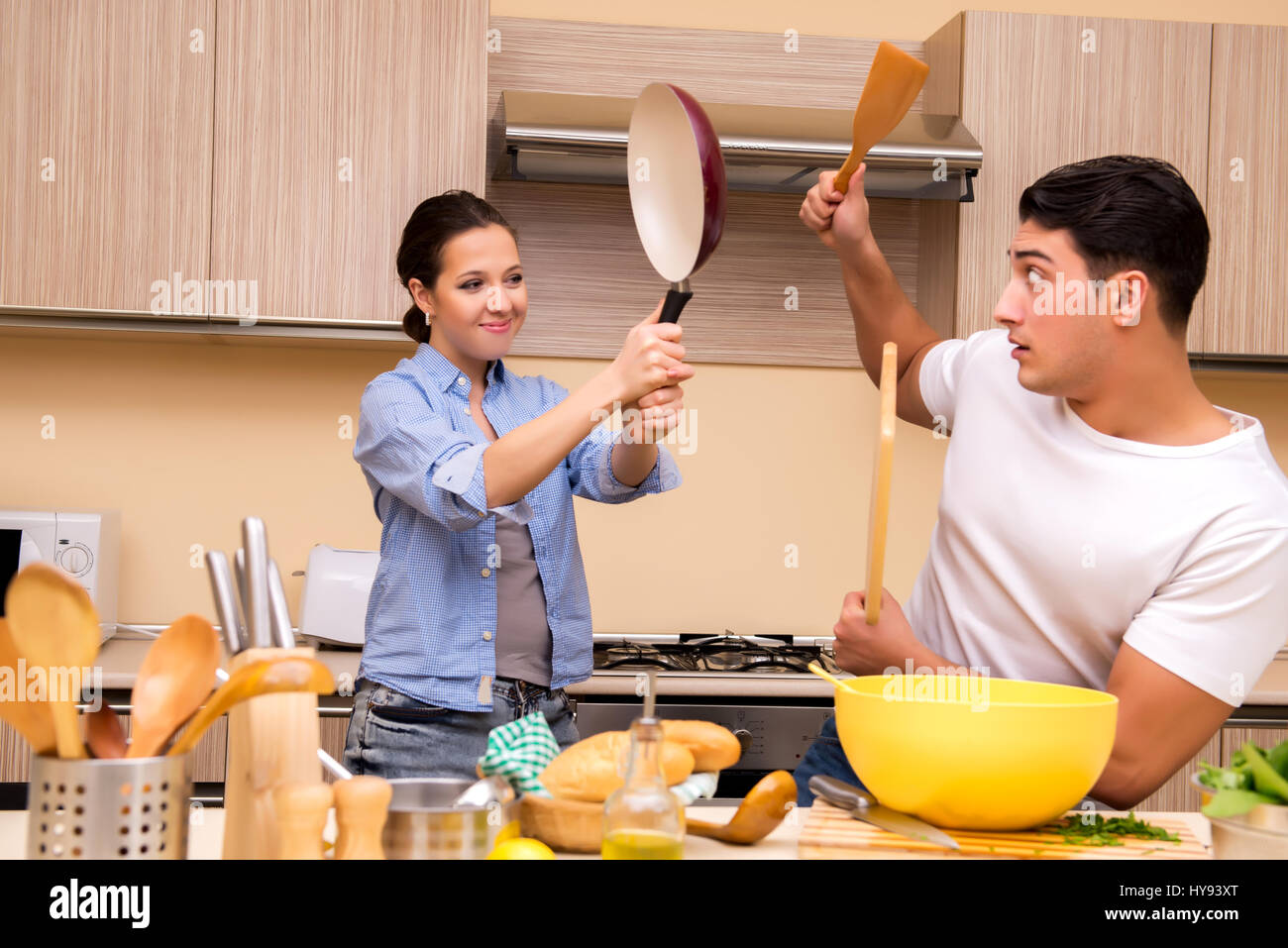 Young family doing funny fight at kitchen Stock Photo - Alamy