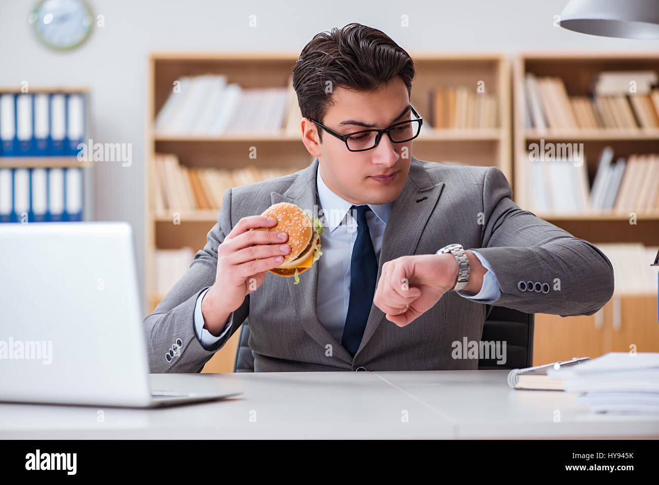Hungry funny businessman eating junk food sandwich Stock Photo - Alamy