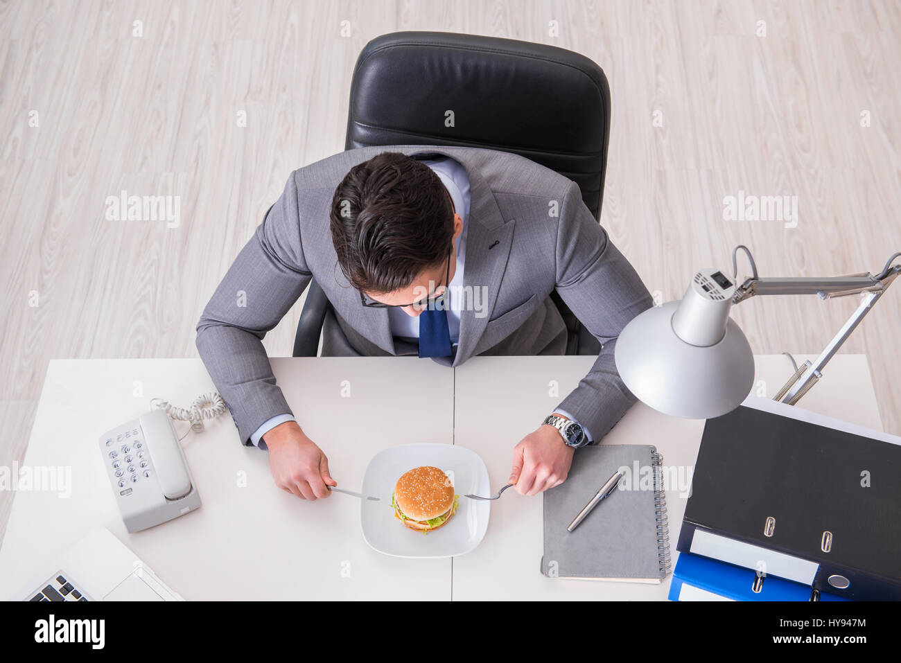 Hungry funny businessman eating junk food sandwich Stock Photo - Alamy