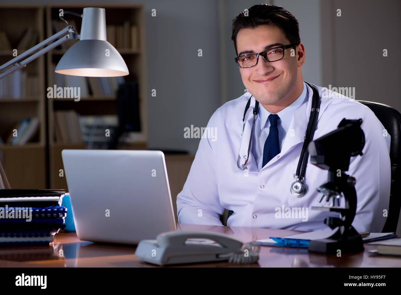 Young doctor working late in the office Stock Photo - Alamy