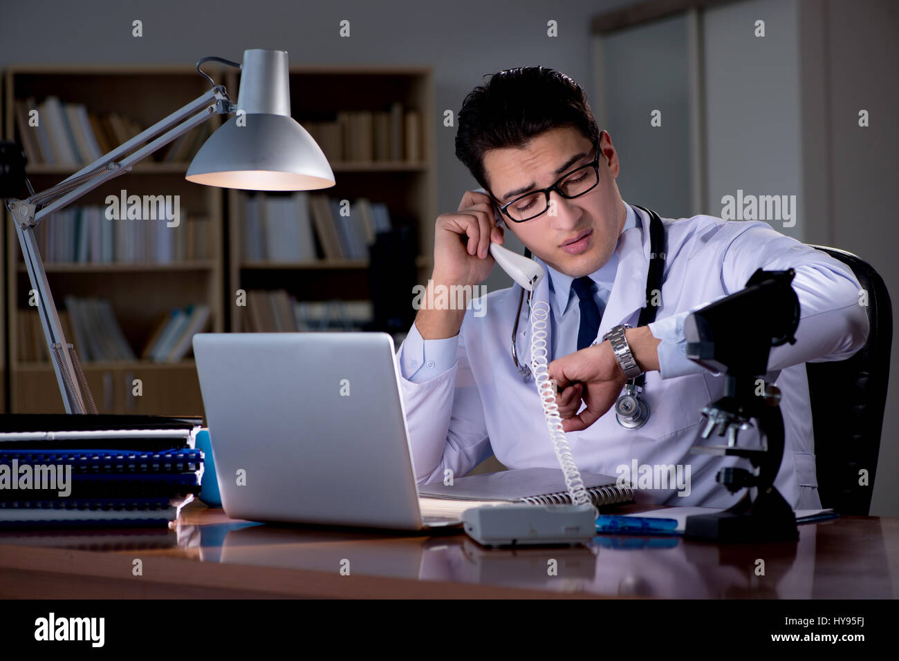 Young doctor working late in the office Stock Photo - Alamy