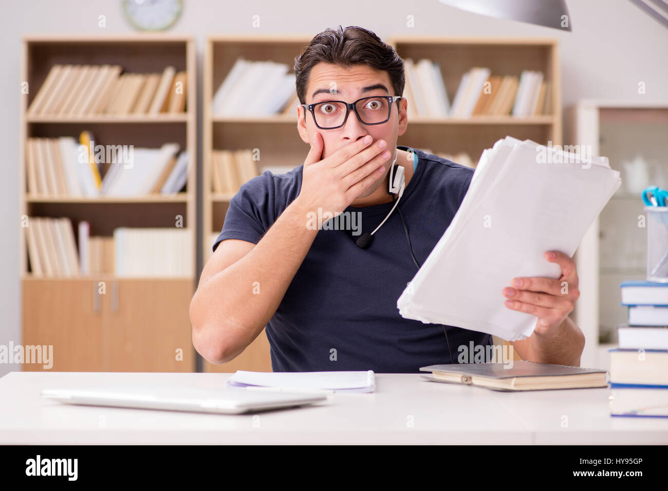 Scared student with paperwork in library Stock Photo - Alamy