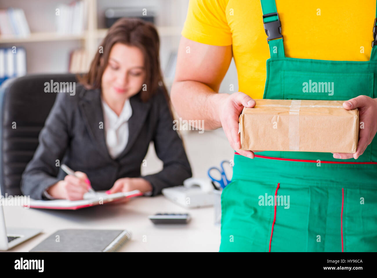 Postman delivering parcel to the office Stock Photo - Alamy