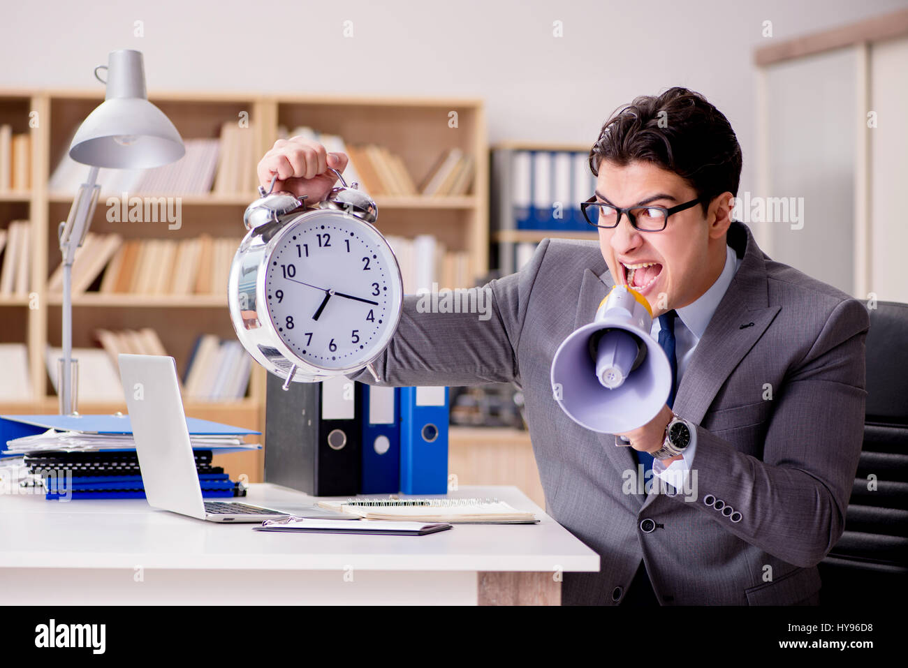 Businessman with loudspeaker megaphone in office Stock Photo - Alamy