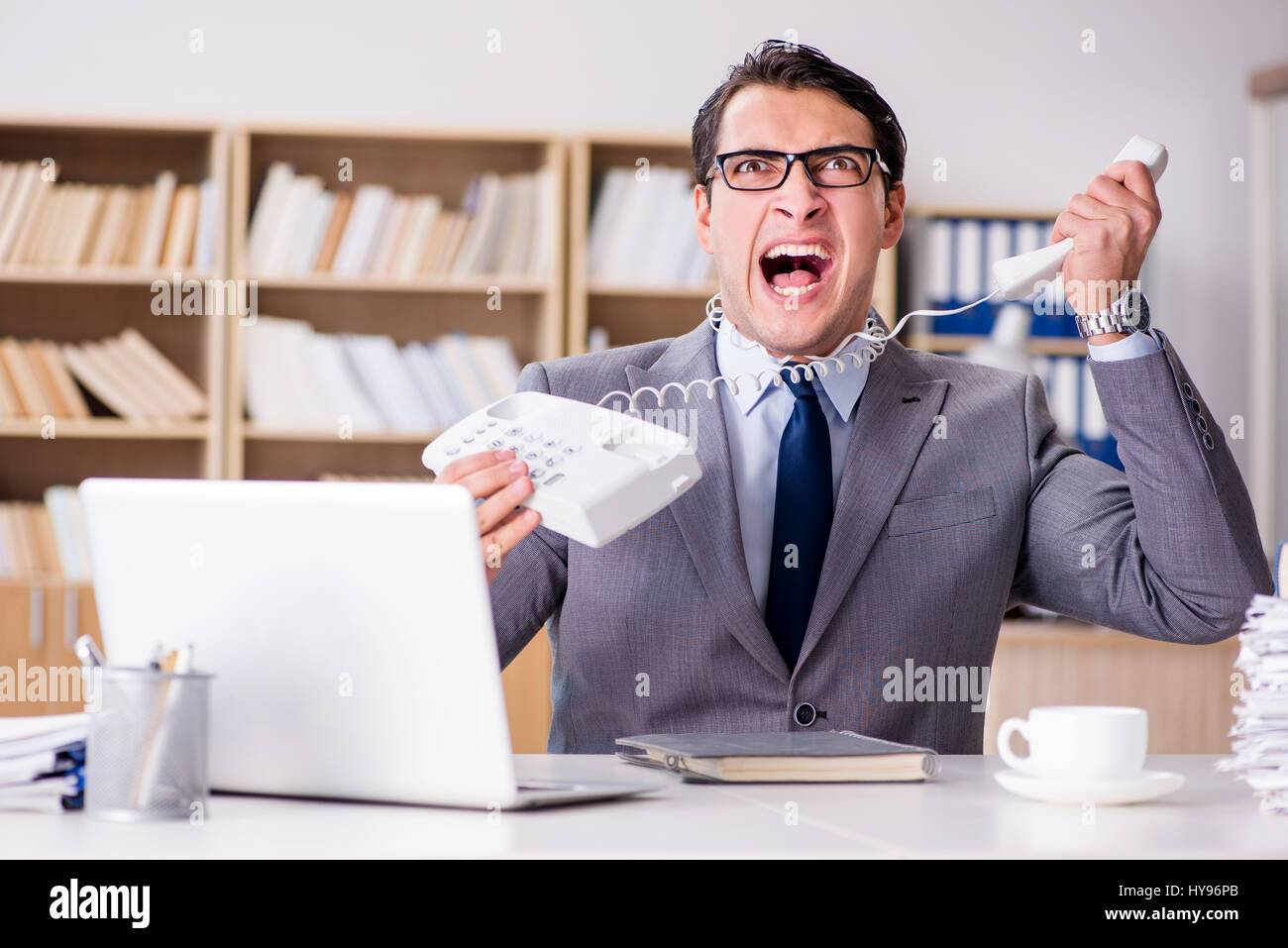 Angry businessman with too much work in office Stock Photo - Alamy