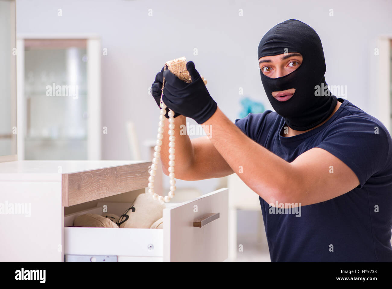 Robber wearing balaclava stealing valuable things Stock Photo - Alamy