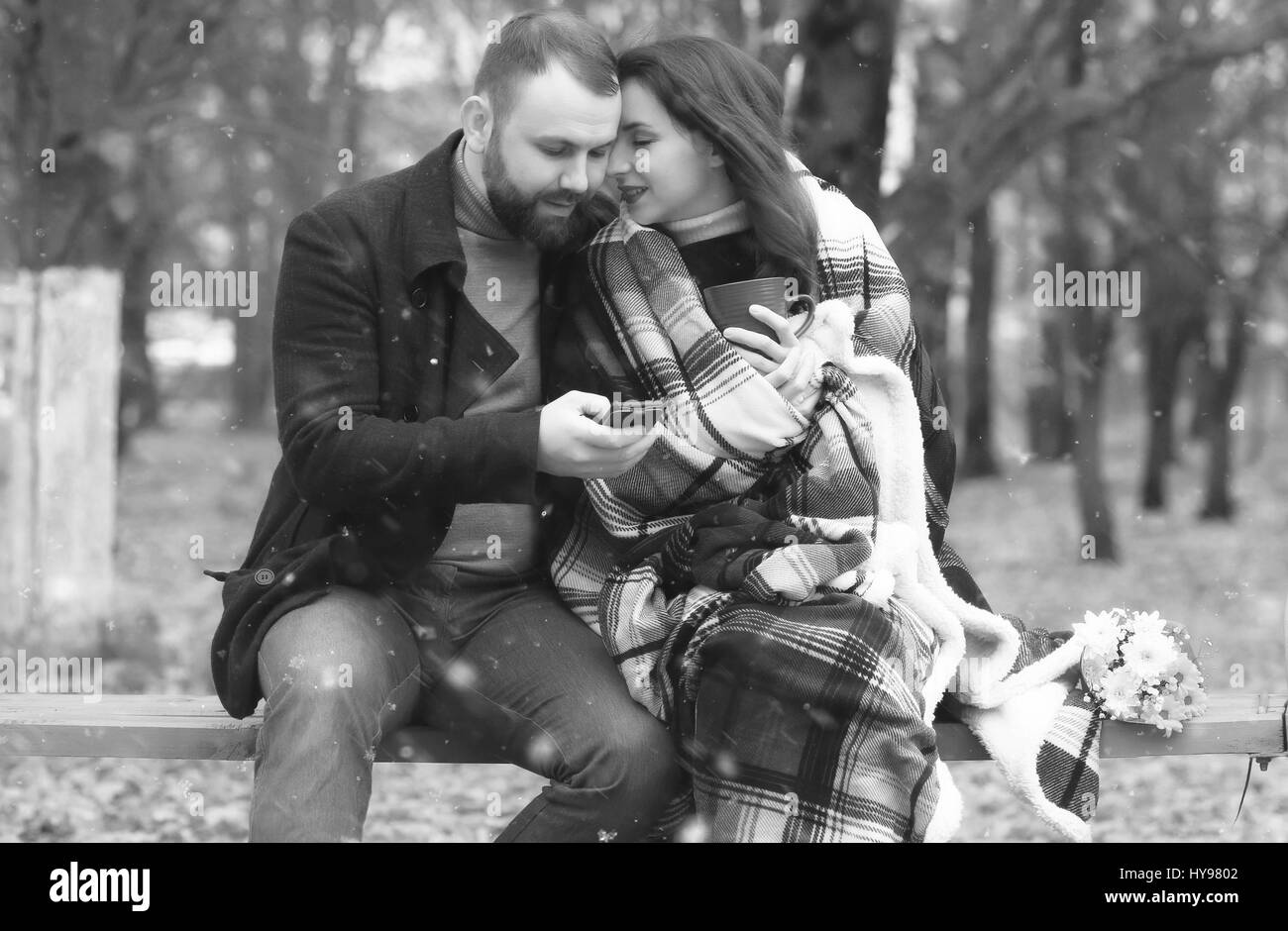 date in a park lovers on a bench in snow Stock Photo - Alamy