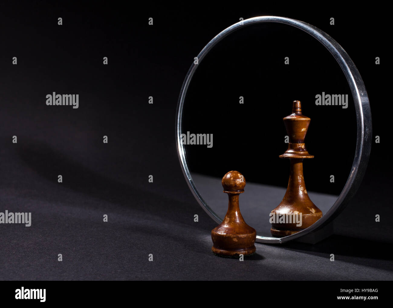 Pawn looking in the mirror and seeing a king. Black background Stock ...