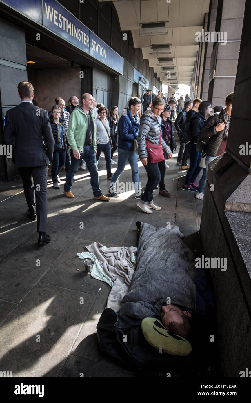 A homeless man sleeps during the day outside Westminster station in ...