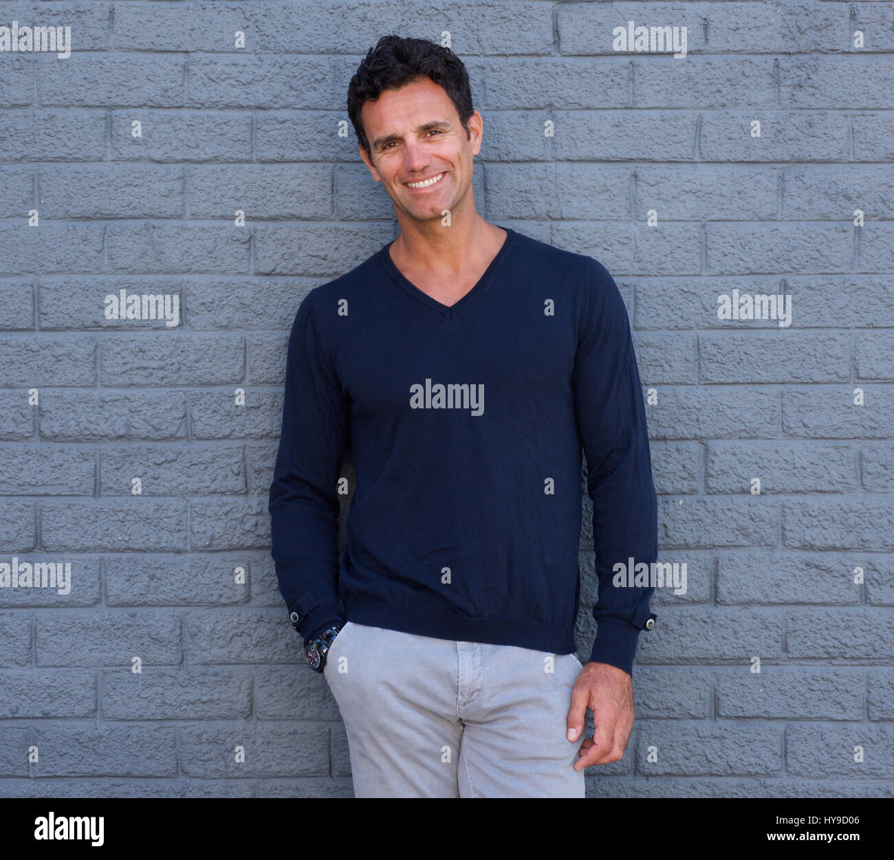 Portrait of a handsome confident man smiling against gray wall Stock ...