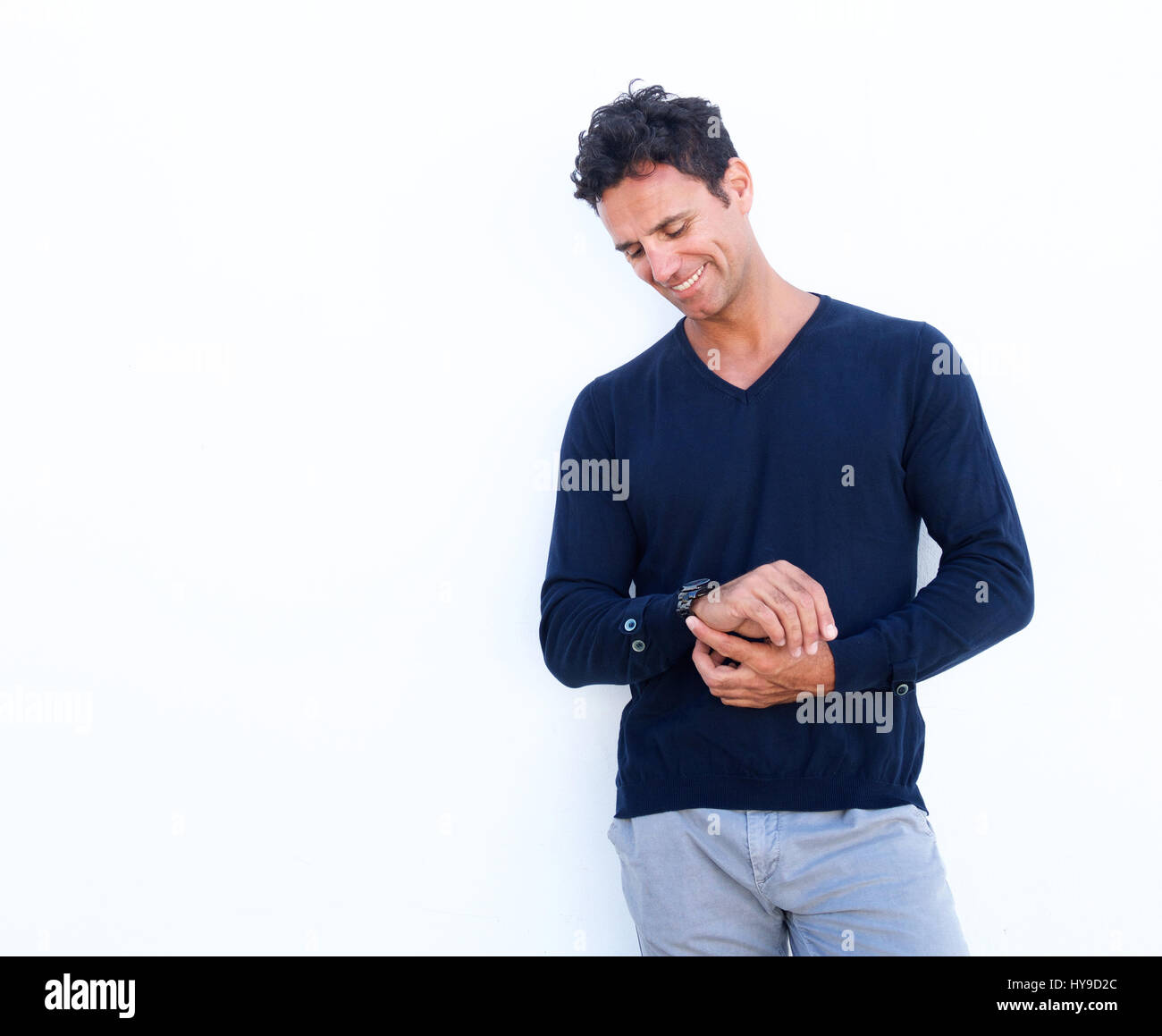 Portrait of a smiling man looking at his watch Stock Photo - Alamy