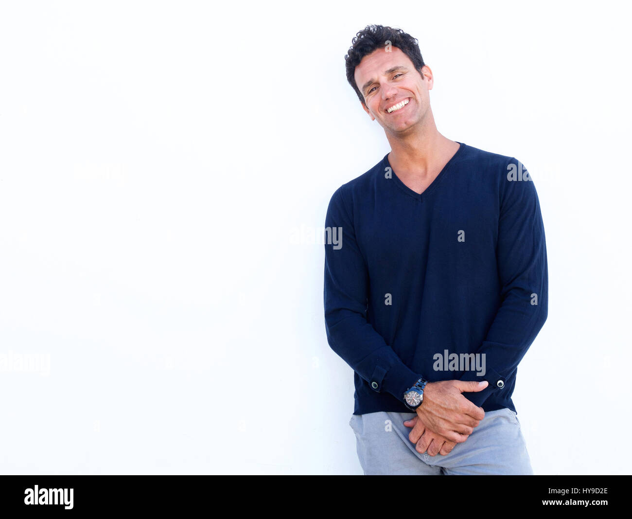 Portrait of a handsome rugged man laughing against white background ...