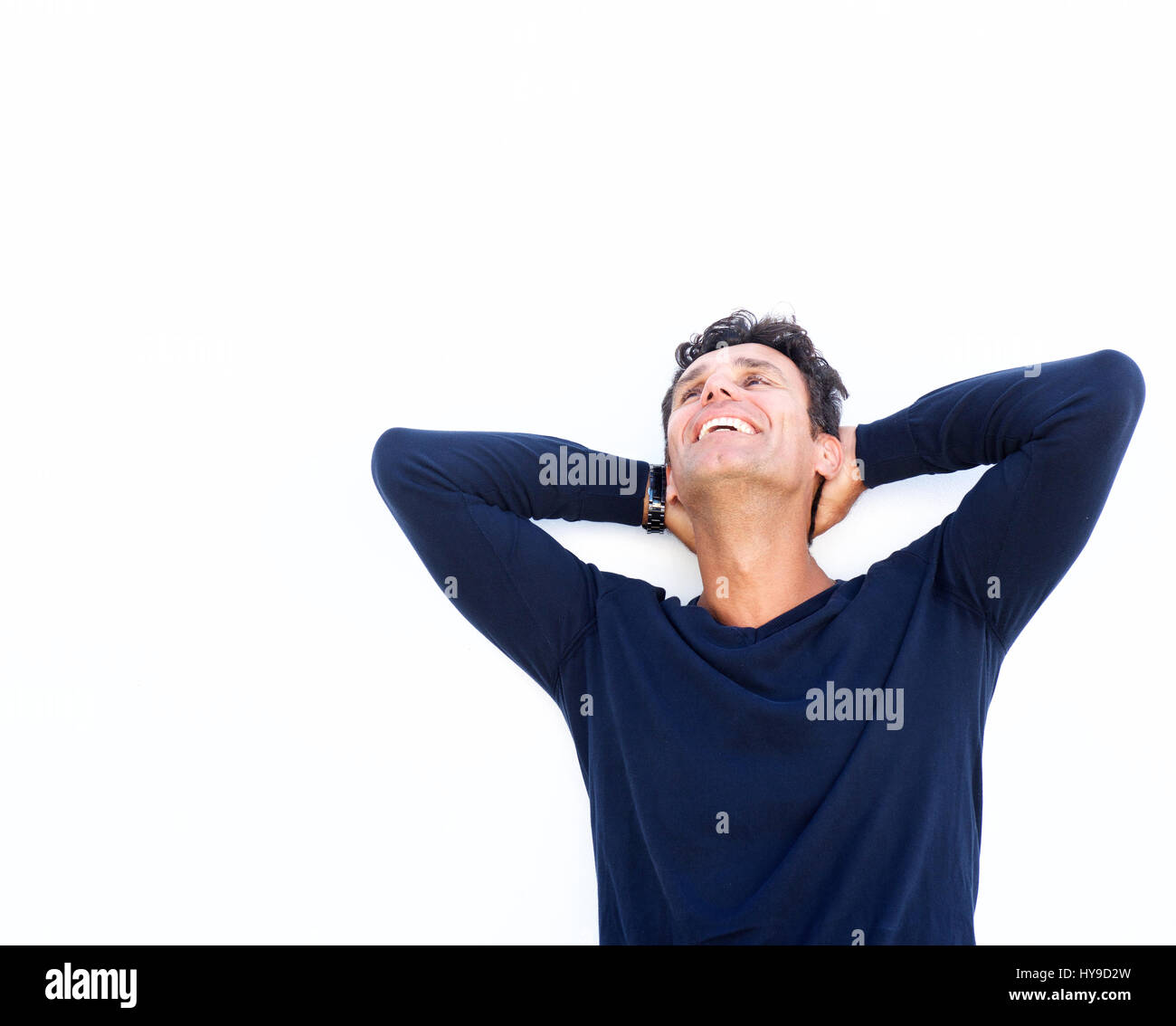 Portrait of a middle aged man laughing with hands behind head against ...