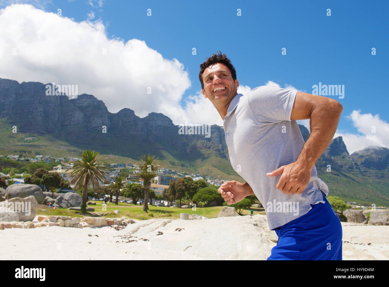 Portrait of a smiling man running at the beach Stock Photo - Alamy