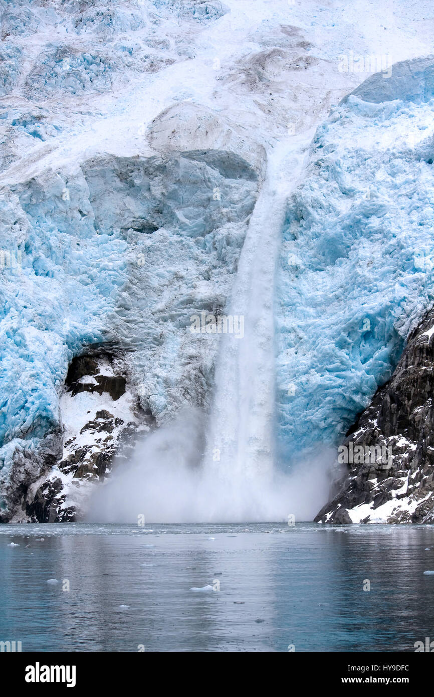 Ice falling and splashing into the sea at a glacier in Kenai Fjords ...