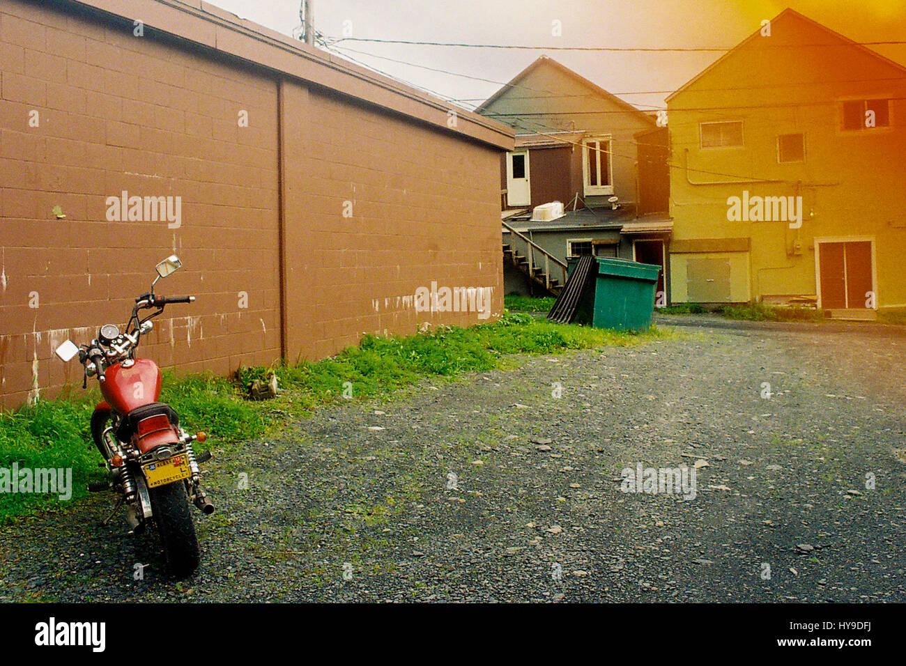 A motorbike is parked on a gravel alley in Alaska with orange film ...