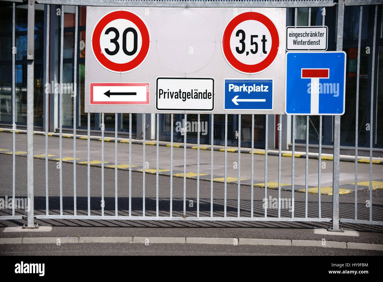 Many different traffic signs at the iron gate of an industrial site ...