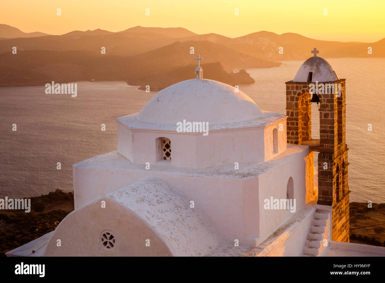 Scenic view of traditional Greek church with ocean background at sunset ...
