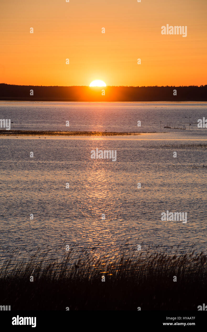beautiful sunrise over country lake with orange clouds and reflections ...