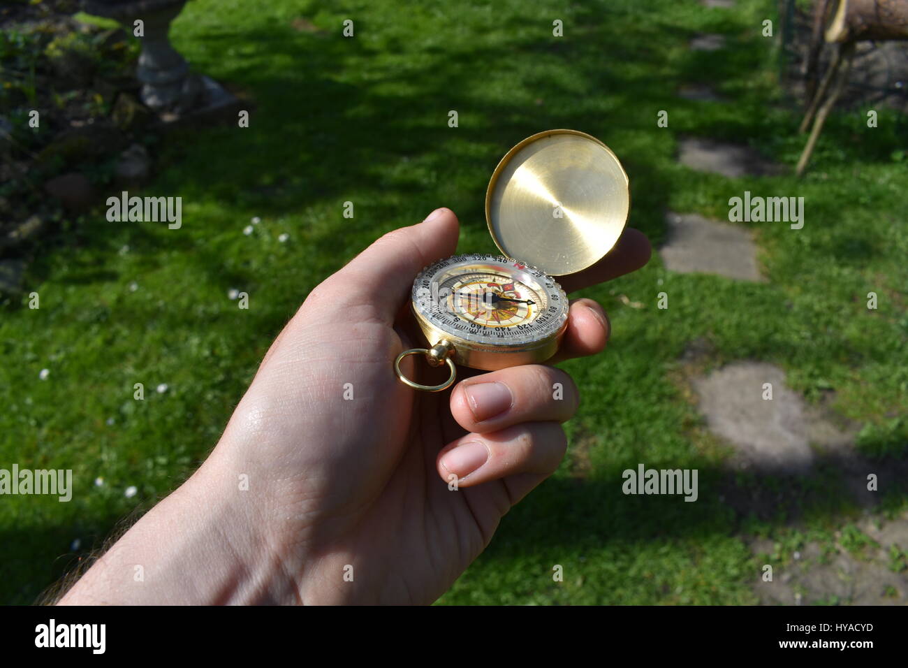 Brass compass in hand Stock Photo - Alamy