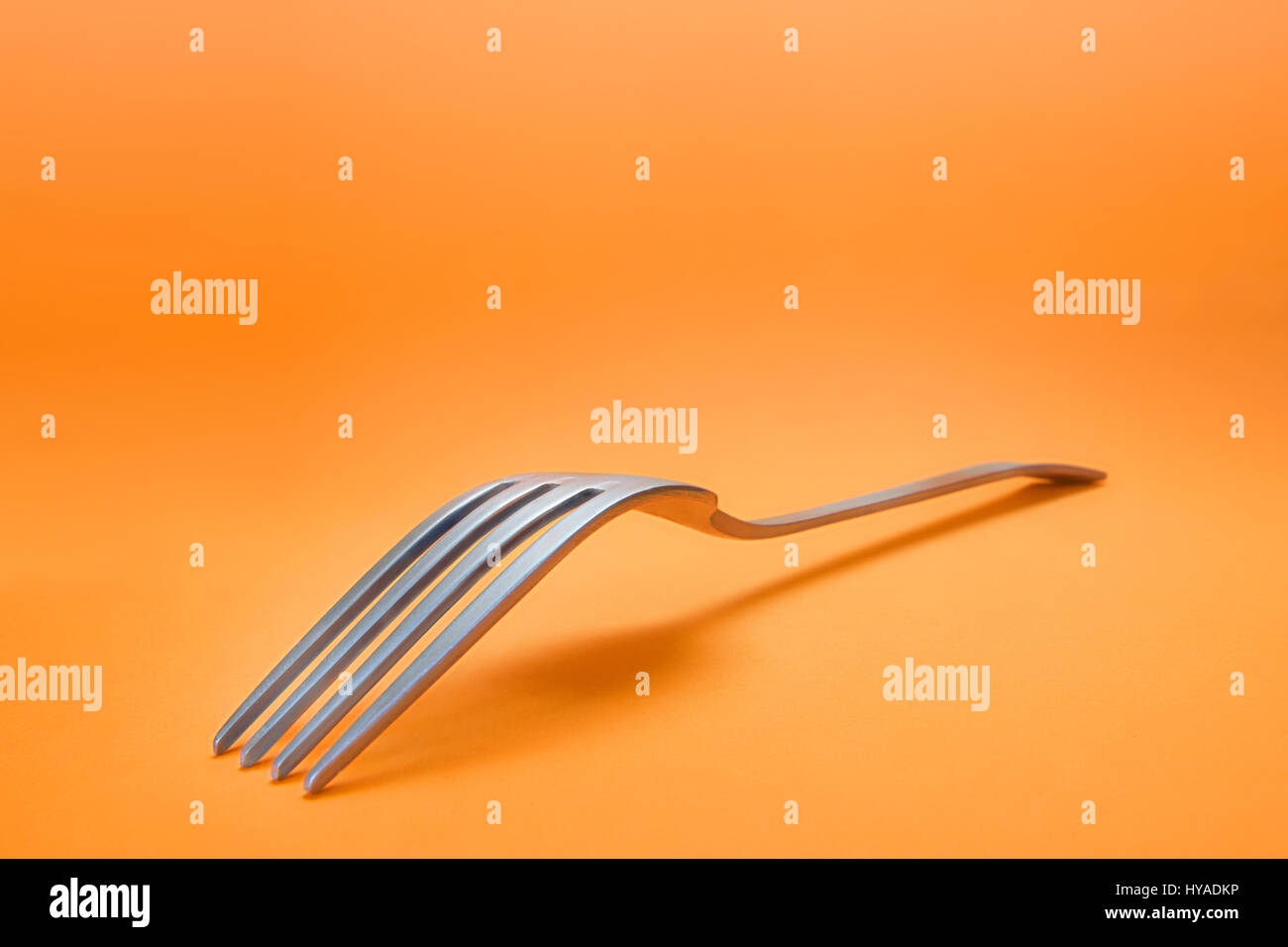Fork on orange background. Wide angle perspective view, selective focus ...