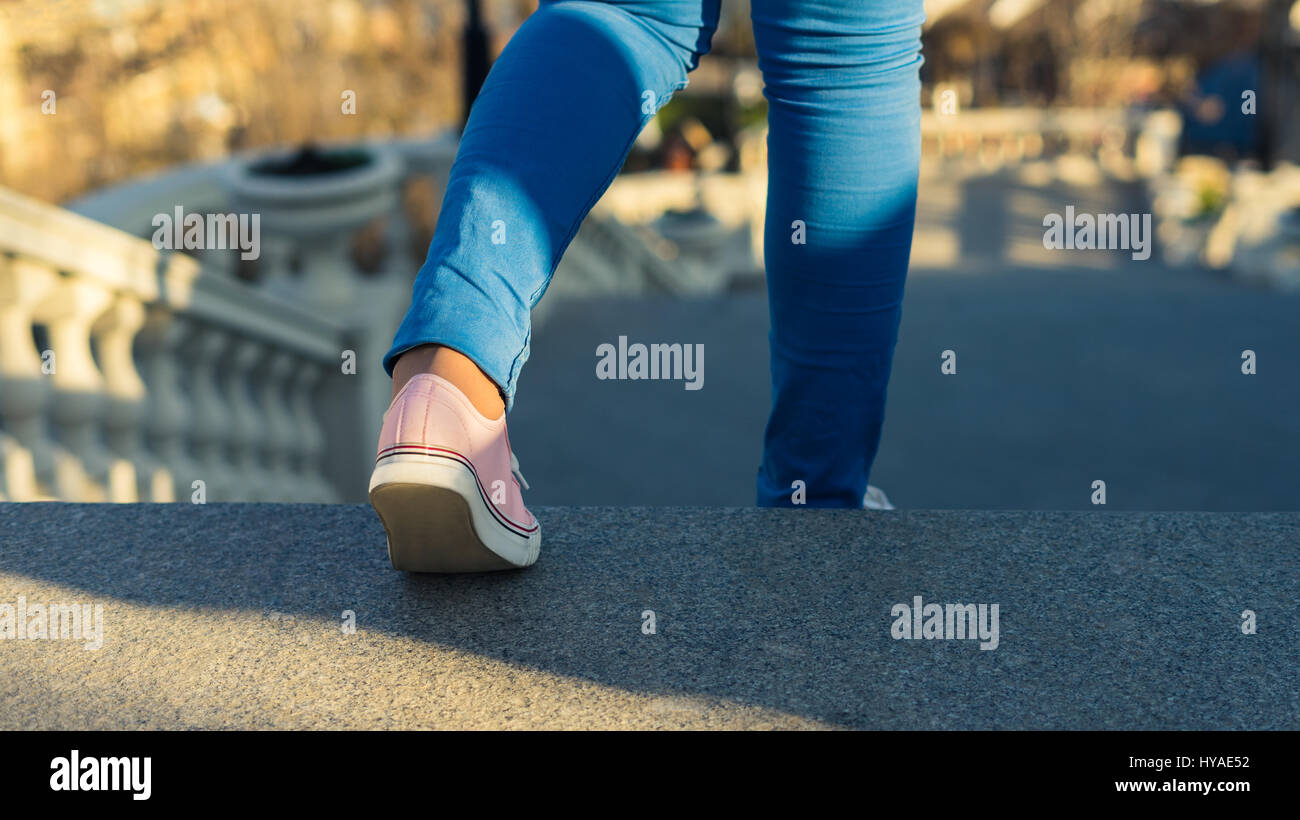 Young girl is walking downstairs on ladder. Step down. She is wearing ...