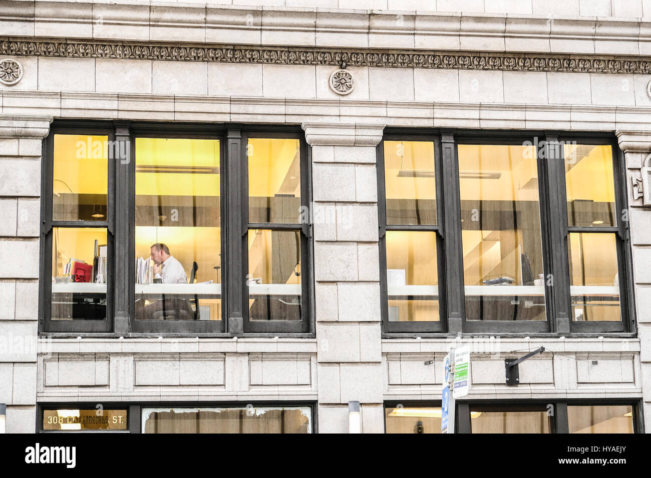 An office worker was seen working at his desk, through a building ...