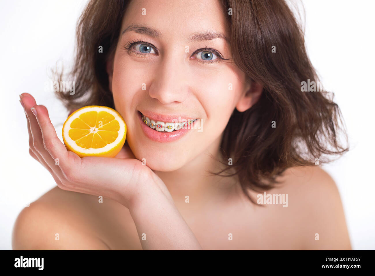 Studio portrait of a girl with multi-colored braces. Isolated on white ...
