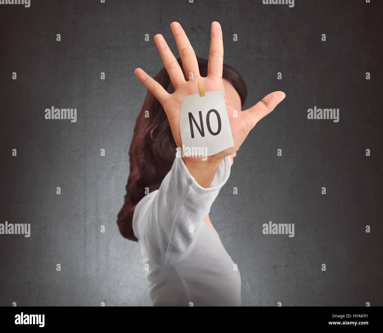 Side view of asian woman showing NO note on her hand against black wall ...