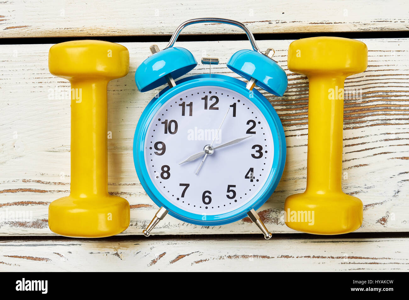 Alarm clock and dumbbells. Lose weight and get healthy Stock Photo - Alamy