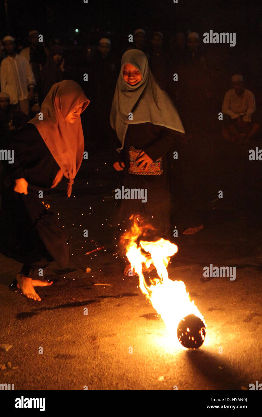 Indonesian muslim women playing a fire football on the street during ...