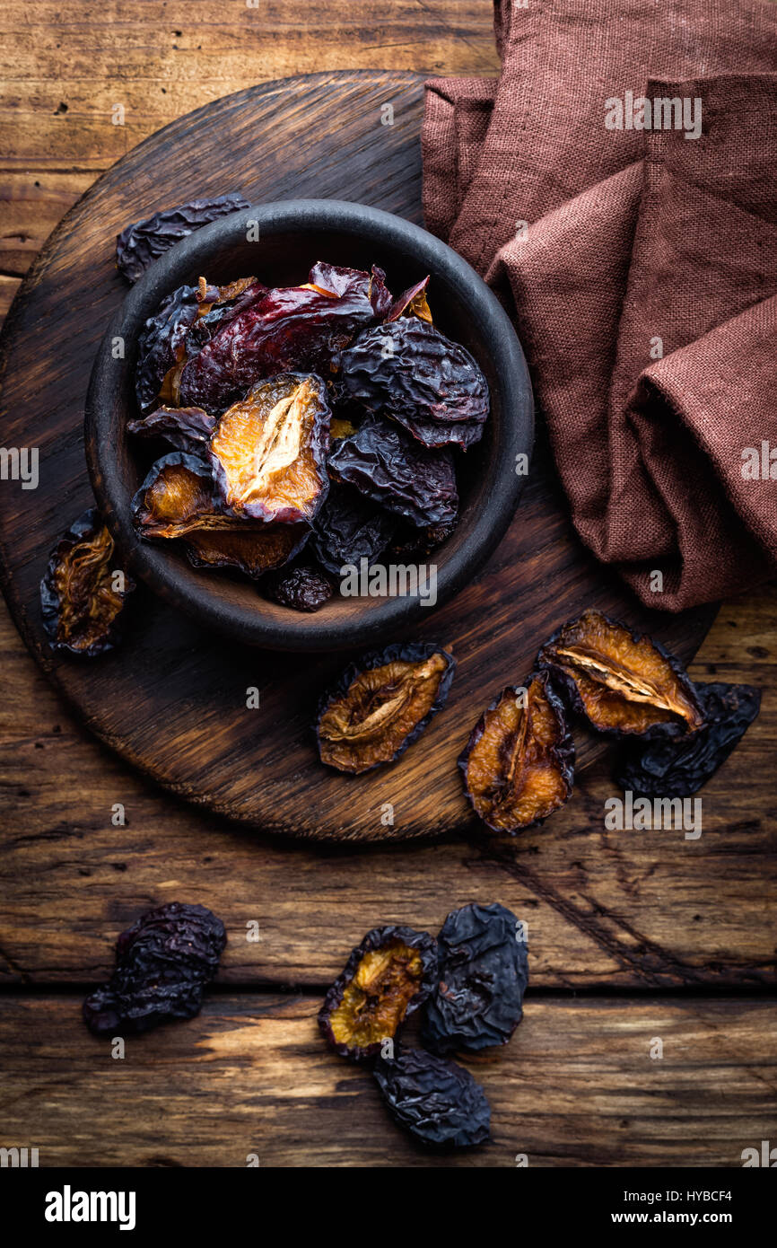 Prune, dried plums fruits on dark rustic wooden background Stock Photo ...