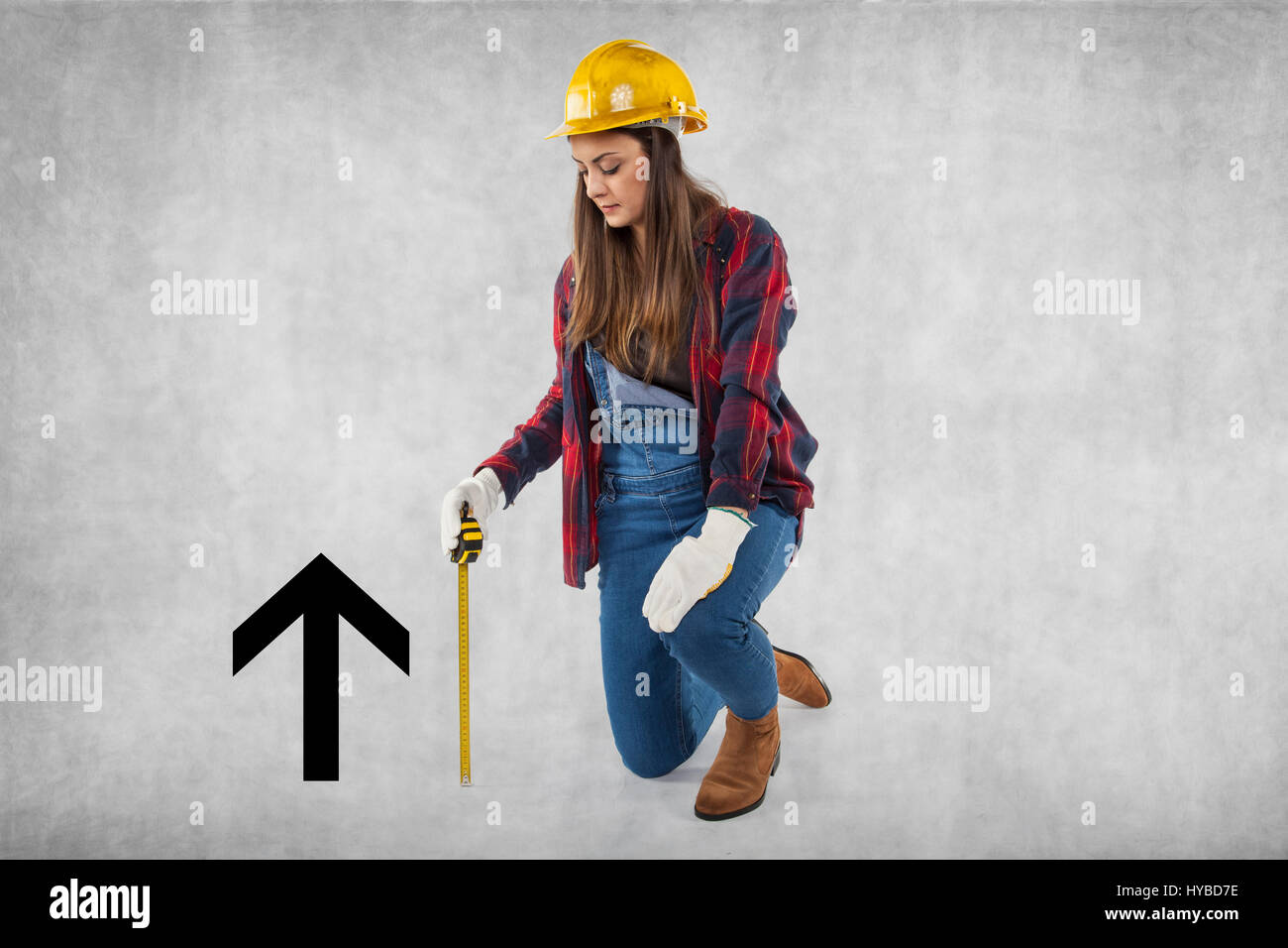 Female construction worker kneeling next to the arrow Stock Photo - Alamy